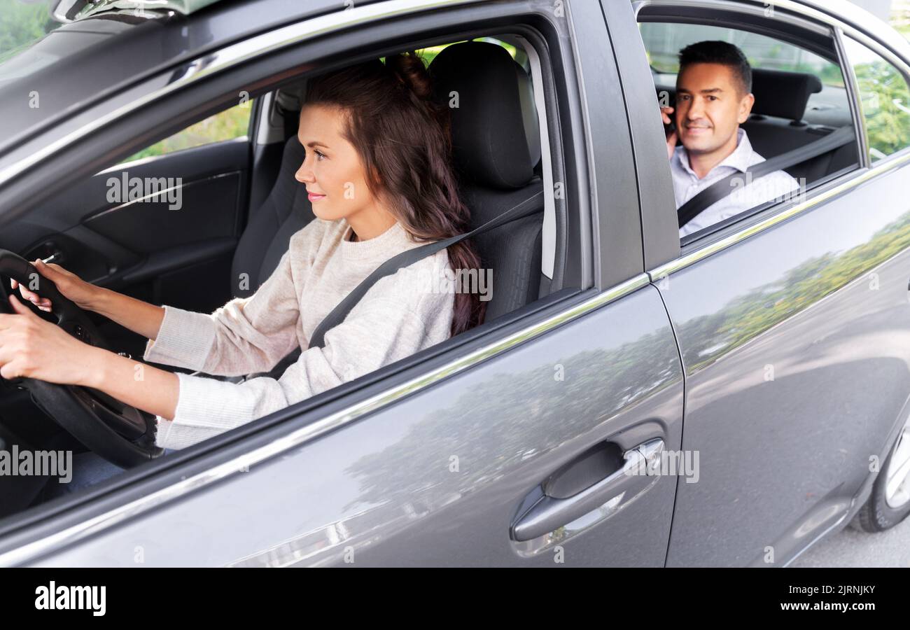 female driver driving car with male passenger Stock Photo - Alamy