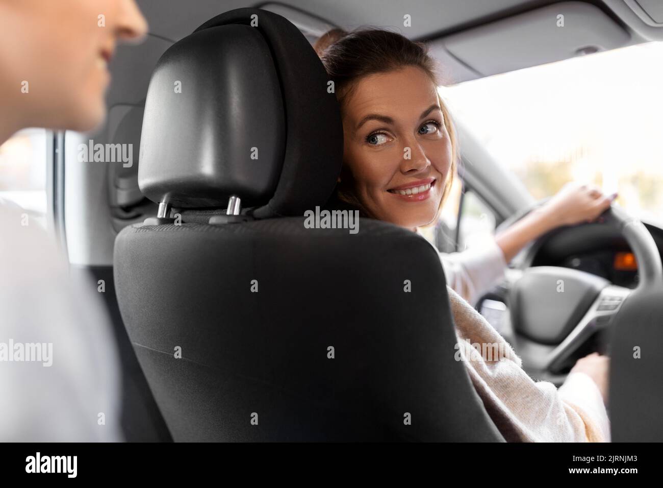 female driver driving car with passenger Stock Photo - Alamy