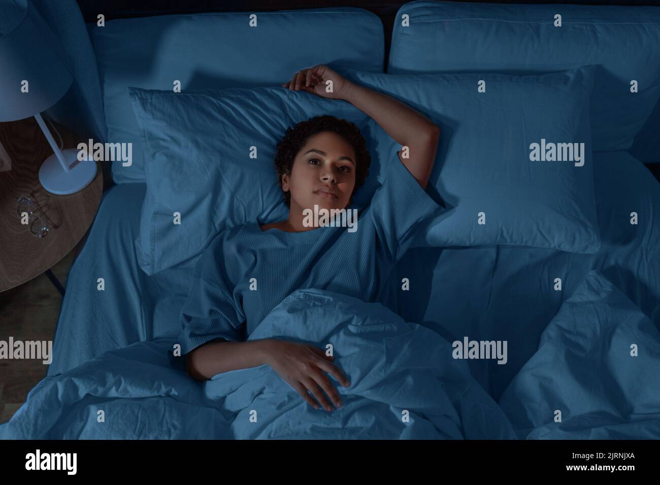 sleepless african woman lying in bed at night Stock Photo - Alamy
