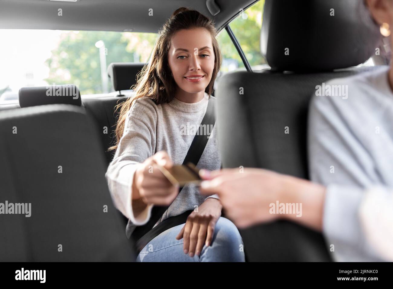 female passenger giving credit card to taxi driver Stock Photo - Alamy