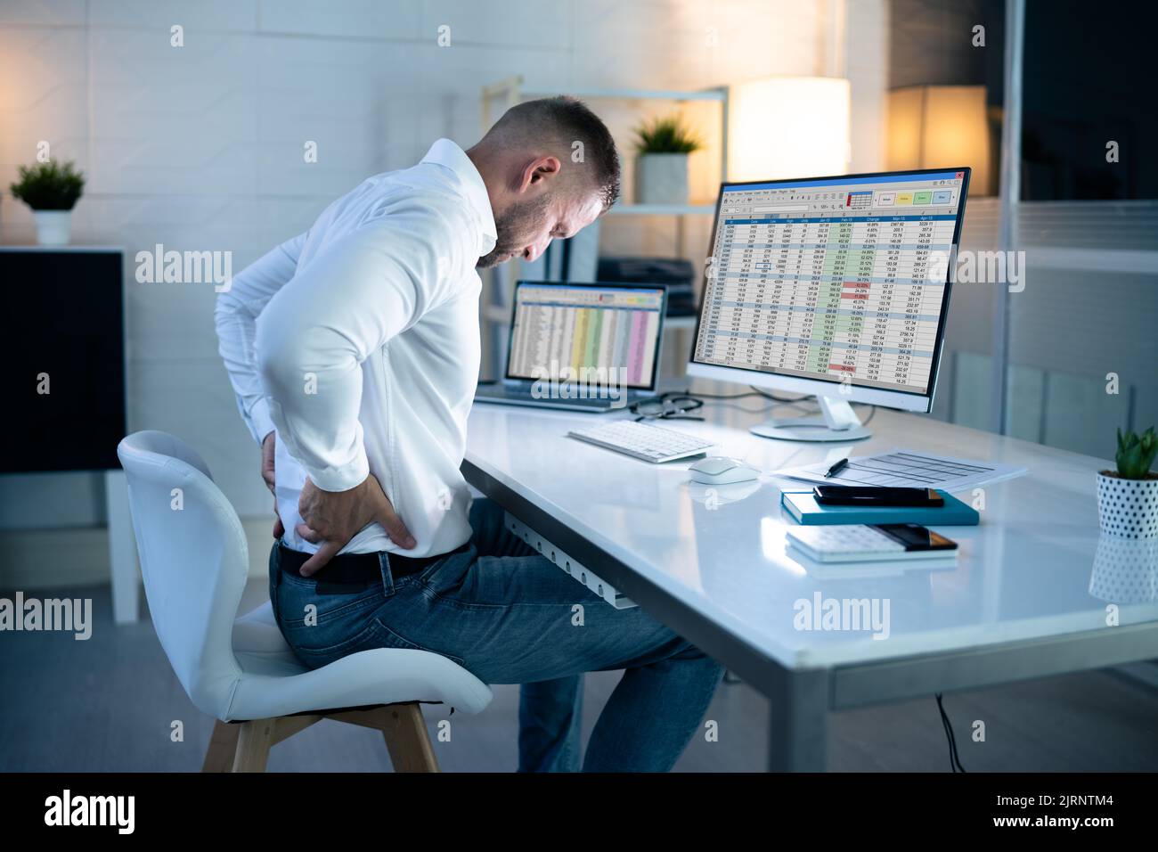 Young Businessman Having Back Pain While Sitting At Office Desk Stock ...