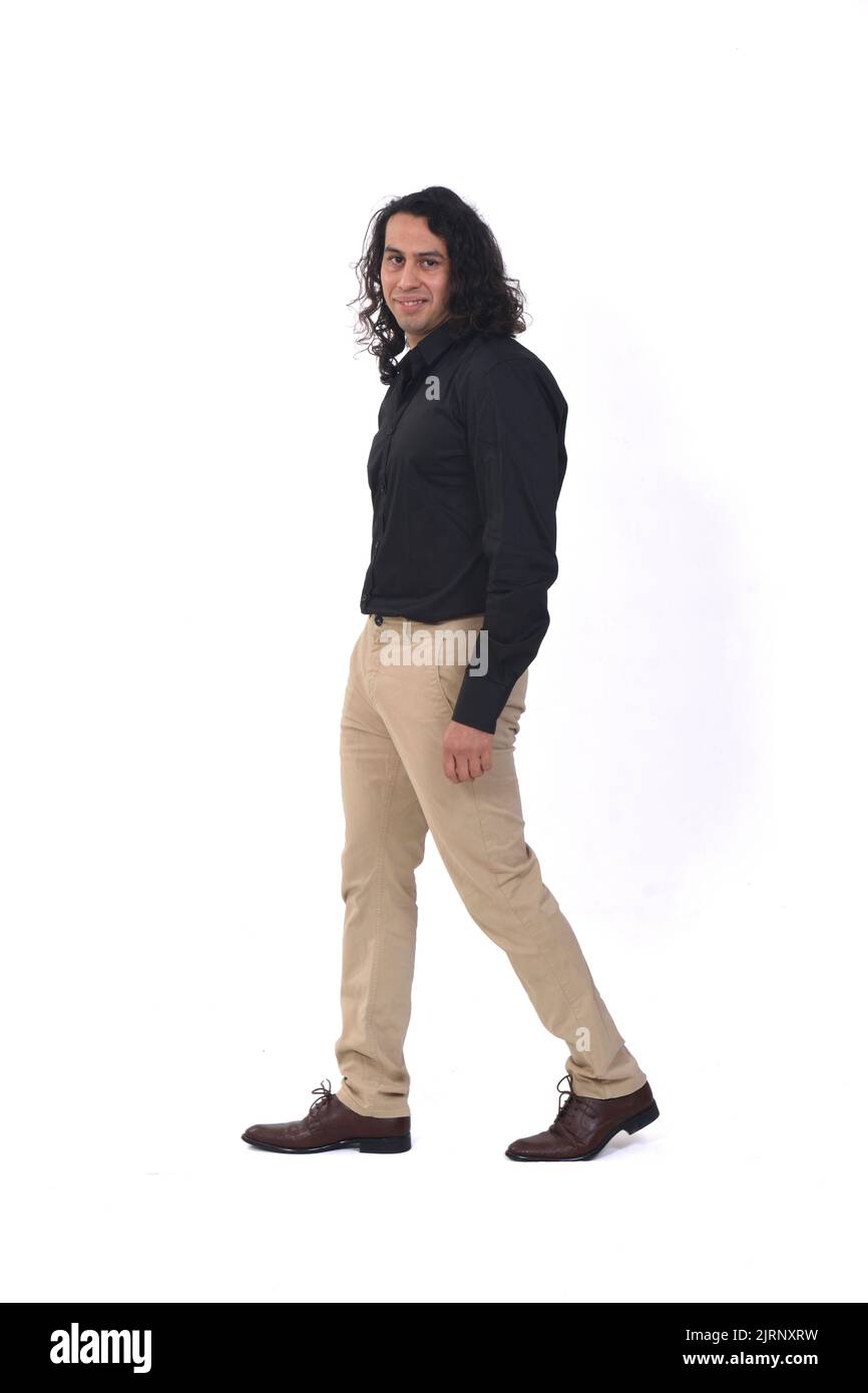 side view of a man with long hair walking and looking at camera on ...