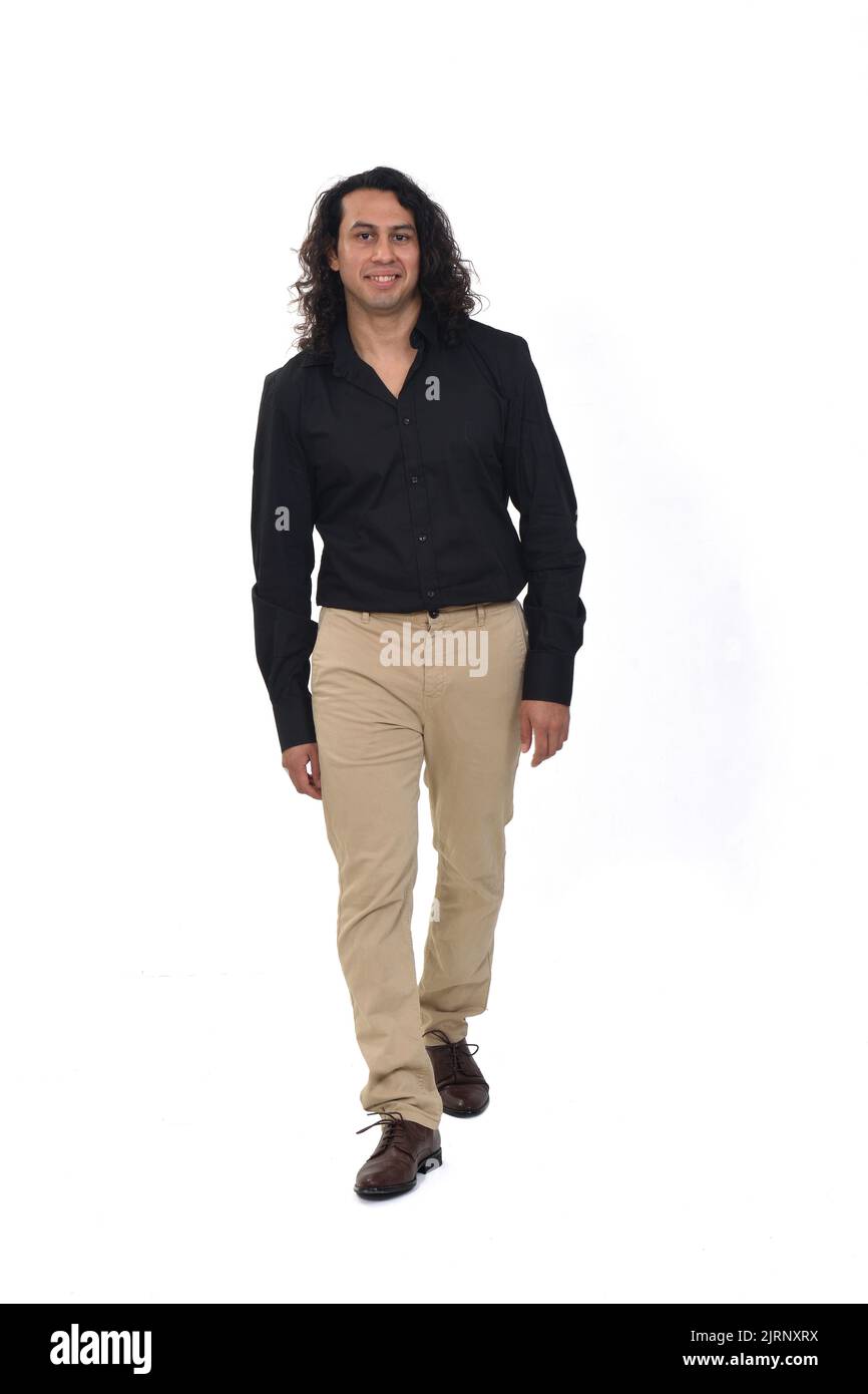 front view of a man with long hair walking and looking at camera and ...
