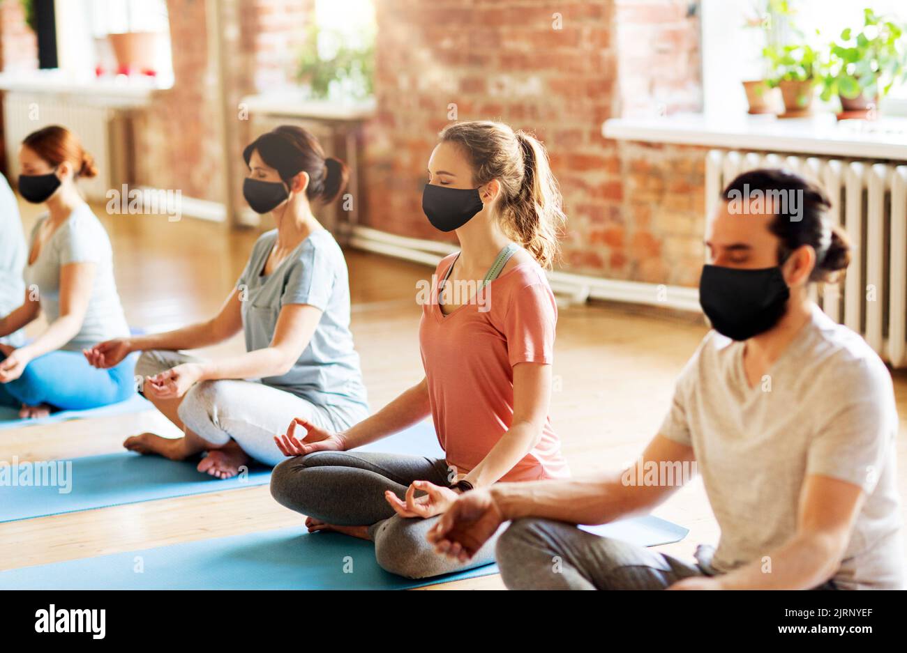 group of people in masks doing yoga at studio Stock Photo - Alamy