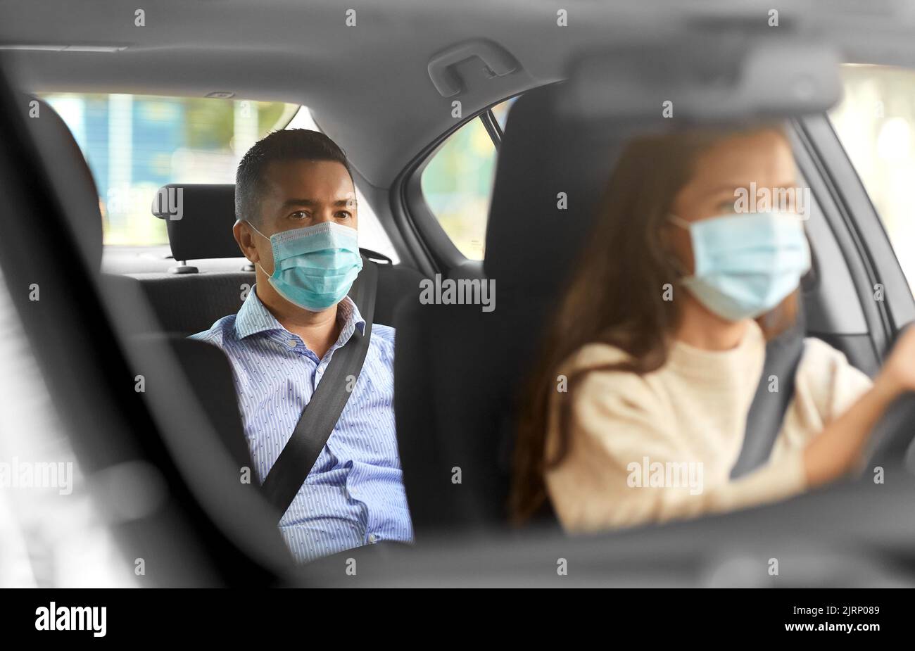 female driver in mask driving car with passenger Stock Photo - Alamy