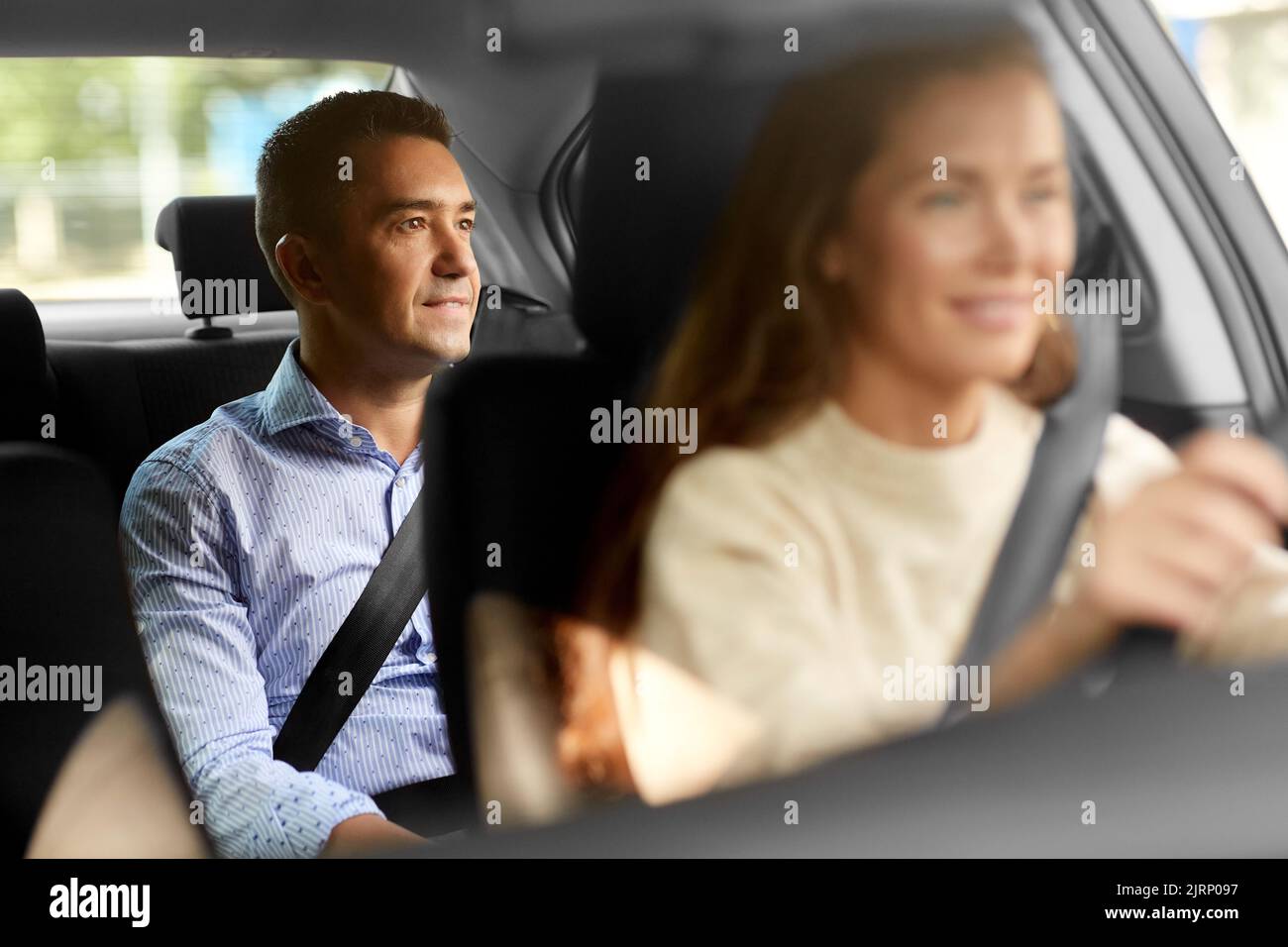 female driver driving car with male passenger Stock Photo - Alamy