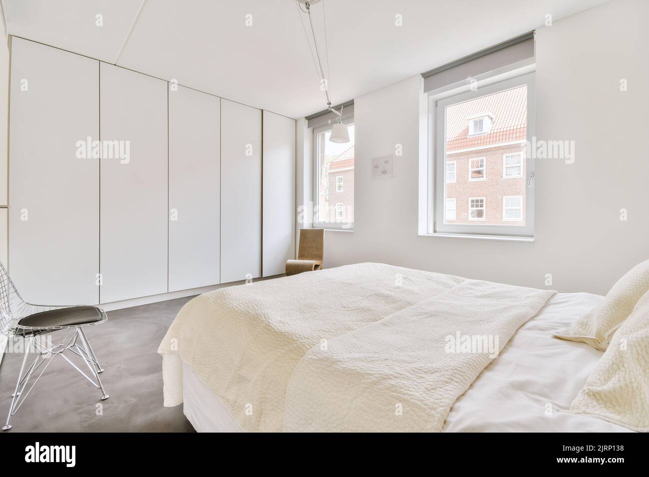 Home interior design of bedroom with bed and wooden wardrobe placed in ...