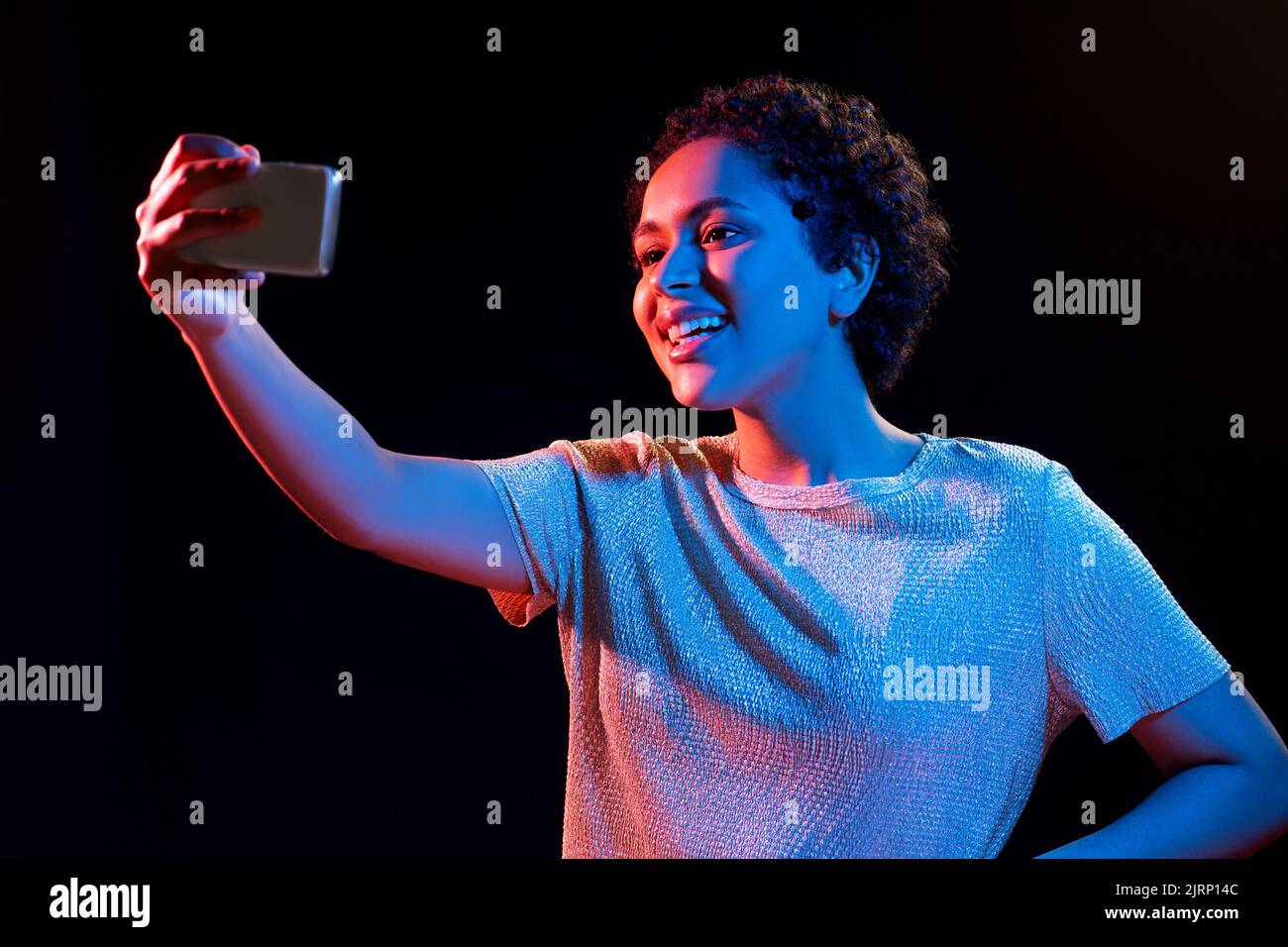 woman taking selfie with smartphone in neon lights Stock Photo - Alamy