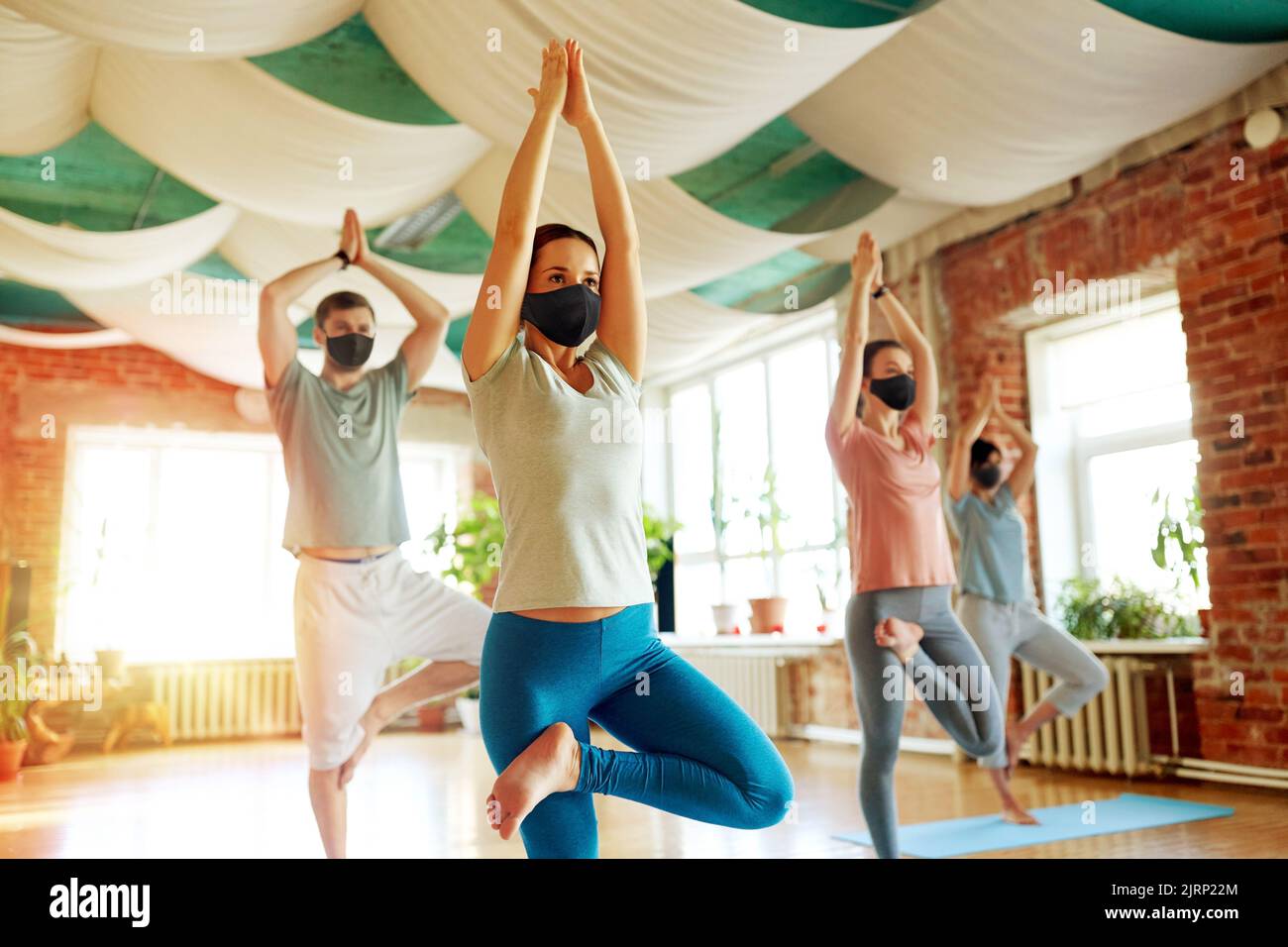 group of people in masks doing yoga at studio Stock Photo - Alamy