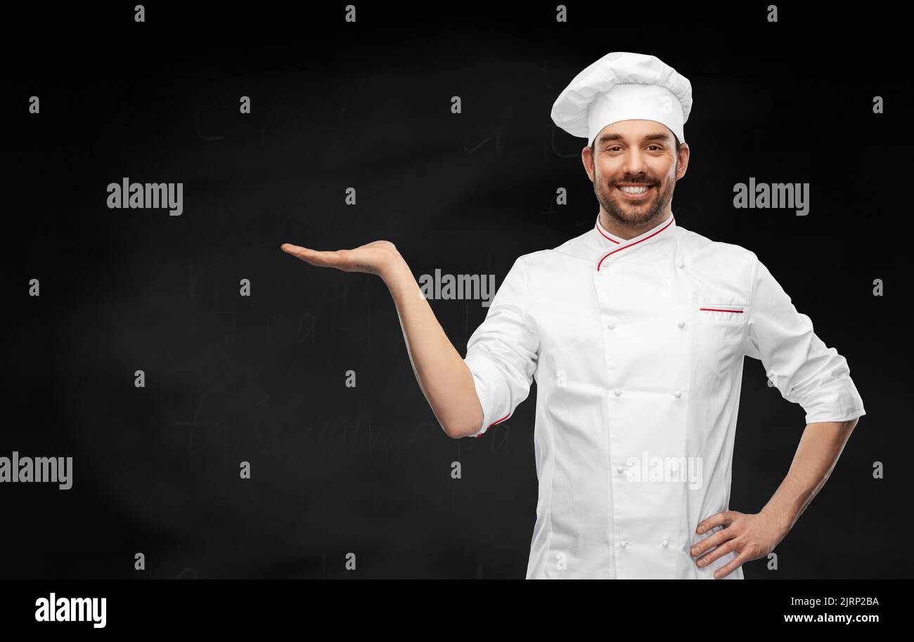happy smiling male chef holding something on hand Stock Photo - Alamy
