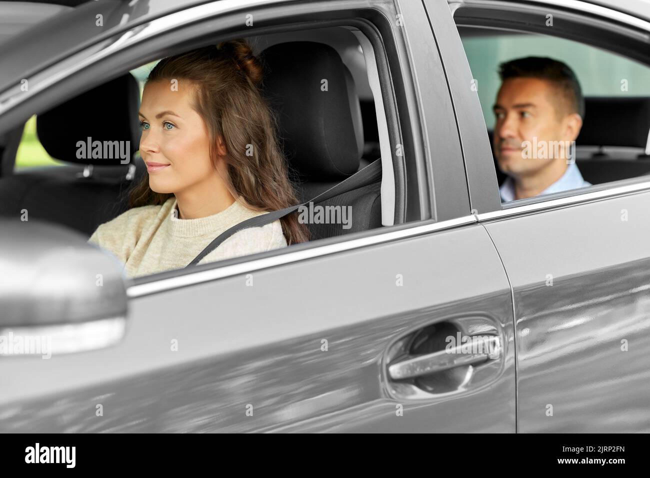 female driver driving car with male passenger Stock Photo - Alamy