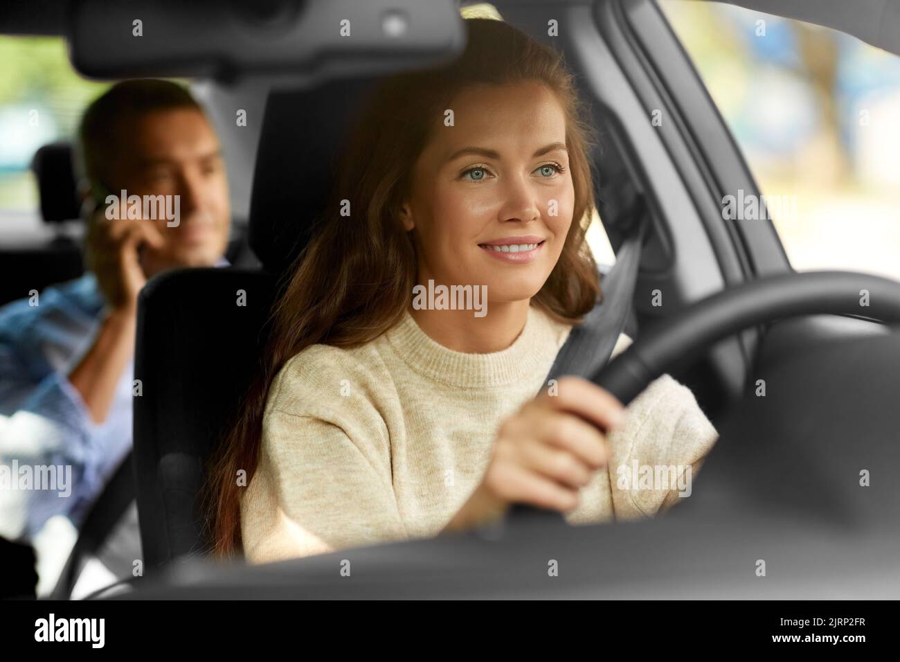 female driver driving car with male passenger Stock Photo - Alamy
