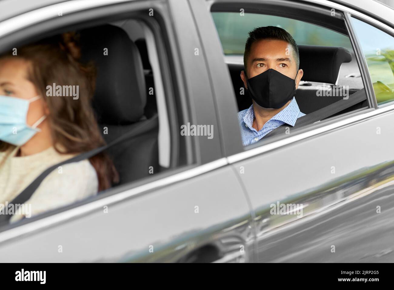 female driver in mask driving car with passenger Stock Photo - Alamy