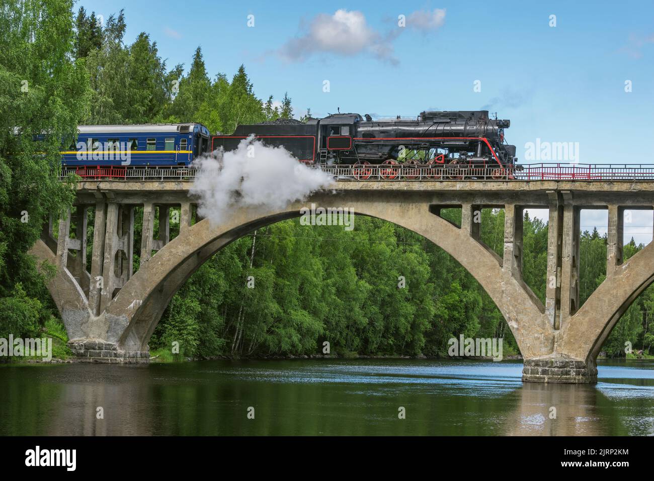 Steam retro train moves on the bridge Stock Photo - Alamy