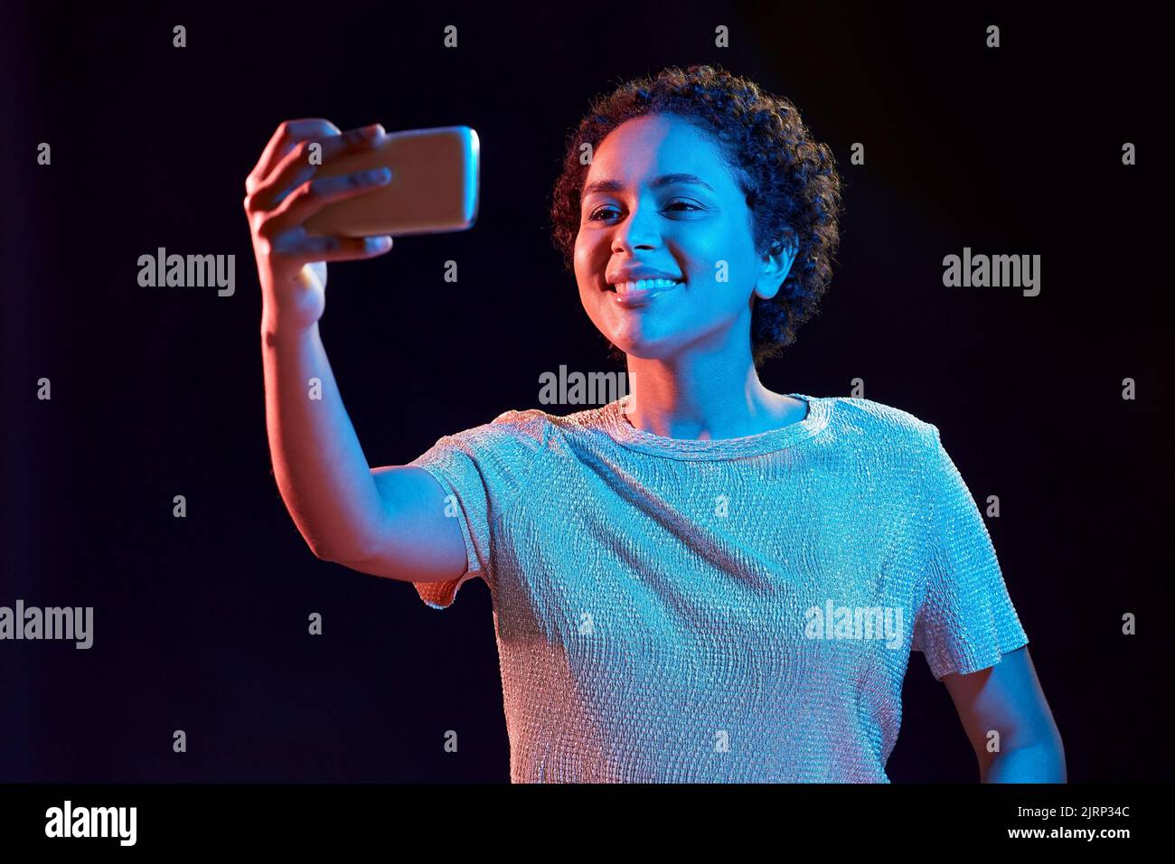 woman taking selfie with smartphone in neon lights Stock Photo - Alamy