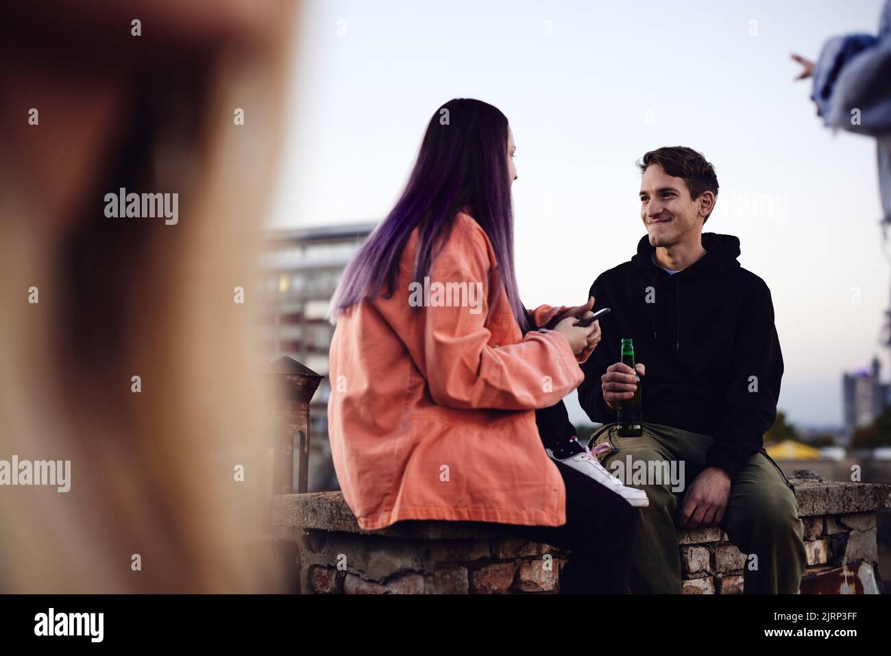 Teenage friends chilling with bottles of beer at roof party Stock Photo ...