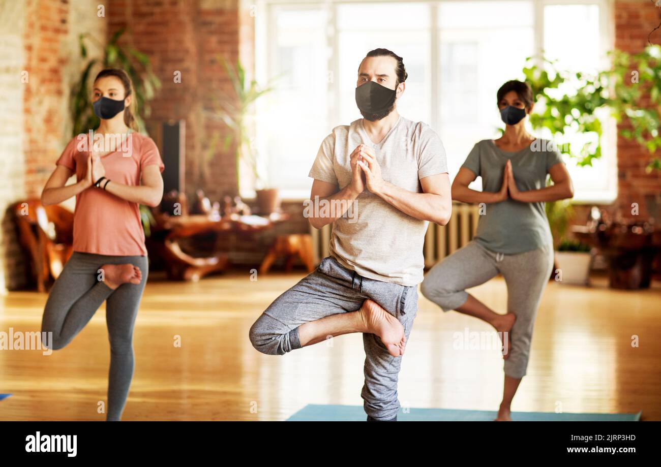 group of people in masks doing yoga at studio Stock Photo - Alamy