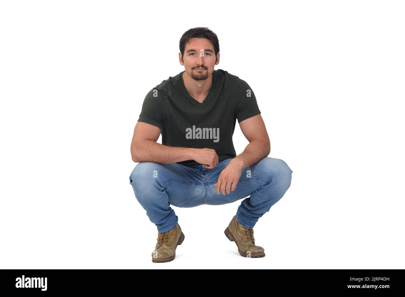 full portrait of a man squatting and looking at camera on white ...