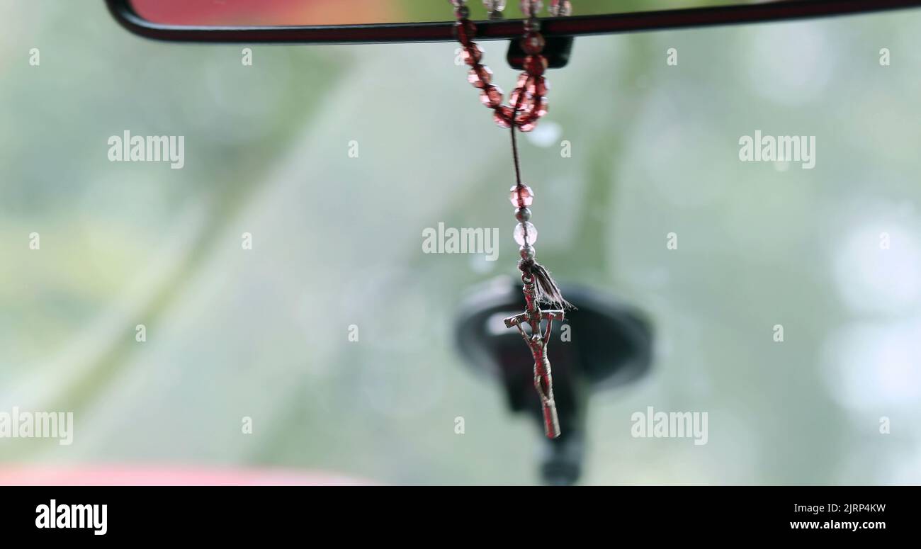 Christian cross icon hanging on car rear-view mirror Stock Photo - Alamy