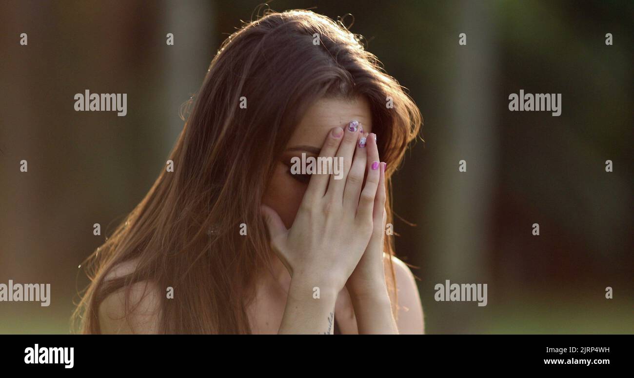 Concerned millennial young woman feeling ashamed and regret in park ...