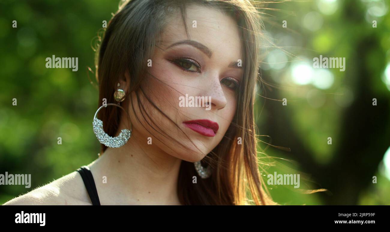 Contemplative young millennial girl posing in outdoor park. Thoughtful ...