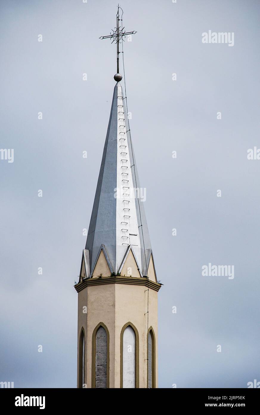 Tower of a Catholic church in a triangular shape, with the cross on top ...