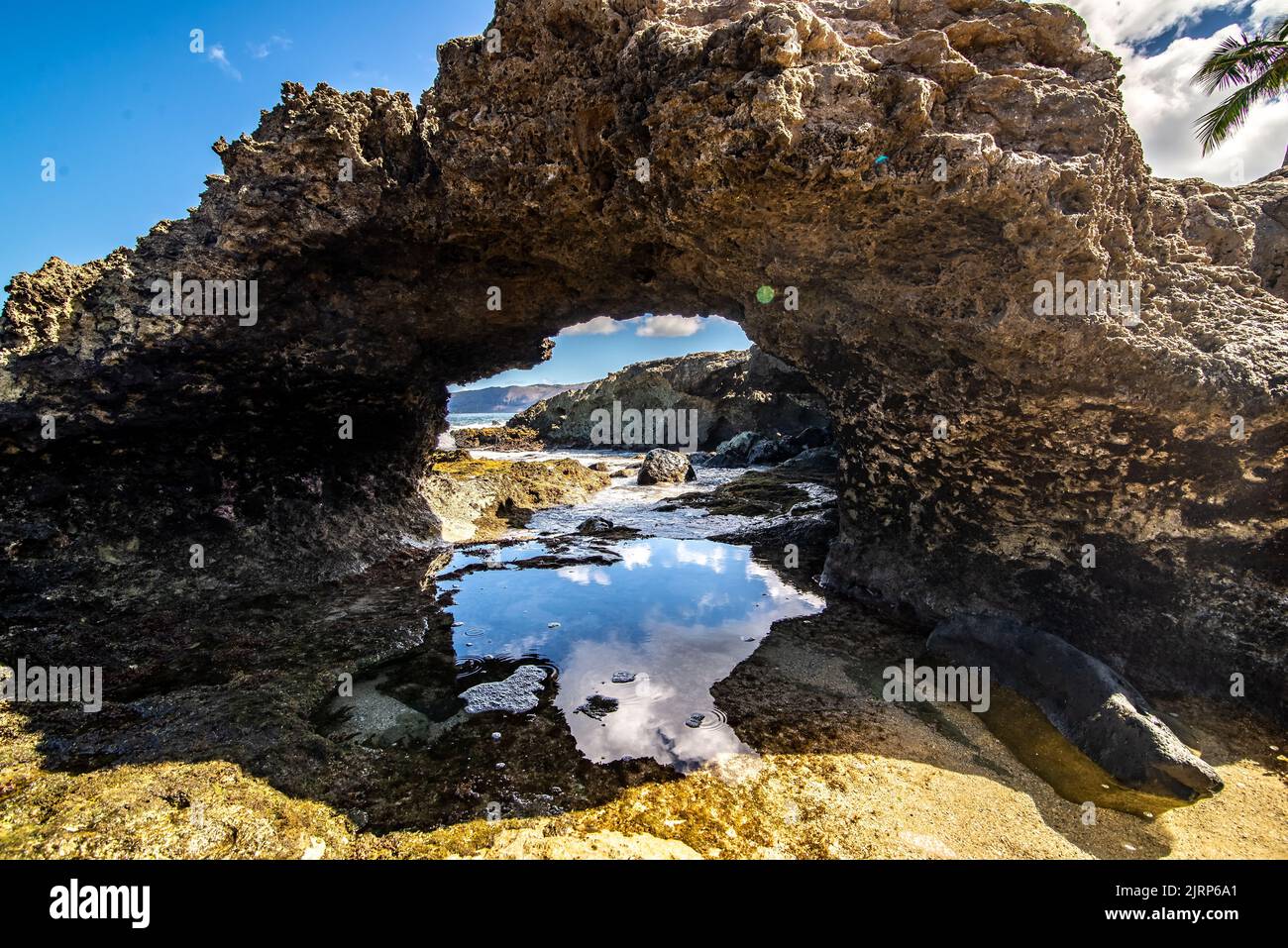 A huge rock with a hole under it on a beach, Oahu, Hawaii Stock Photo ...