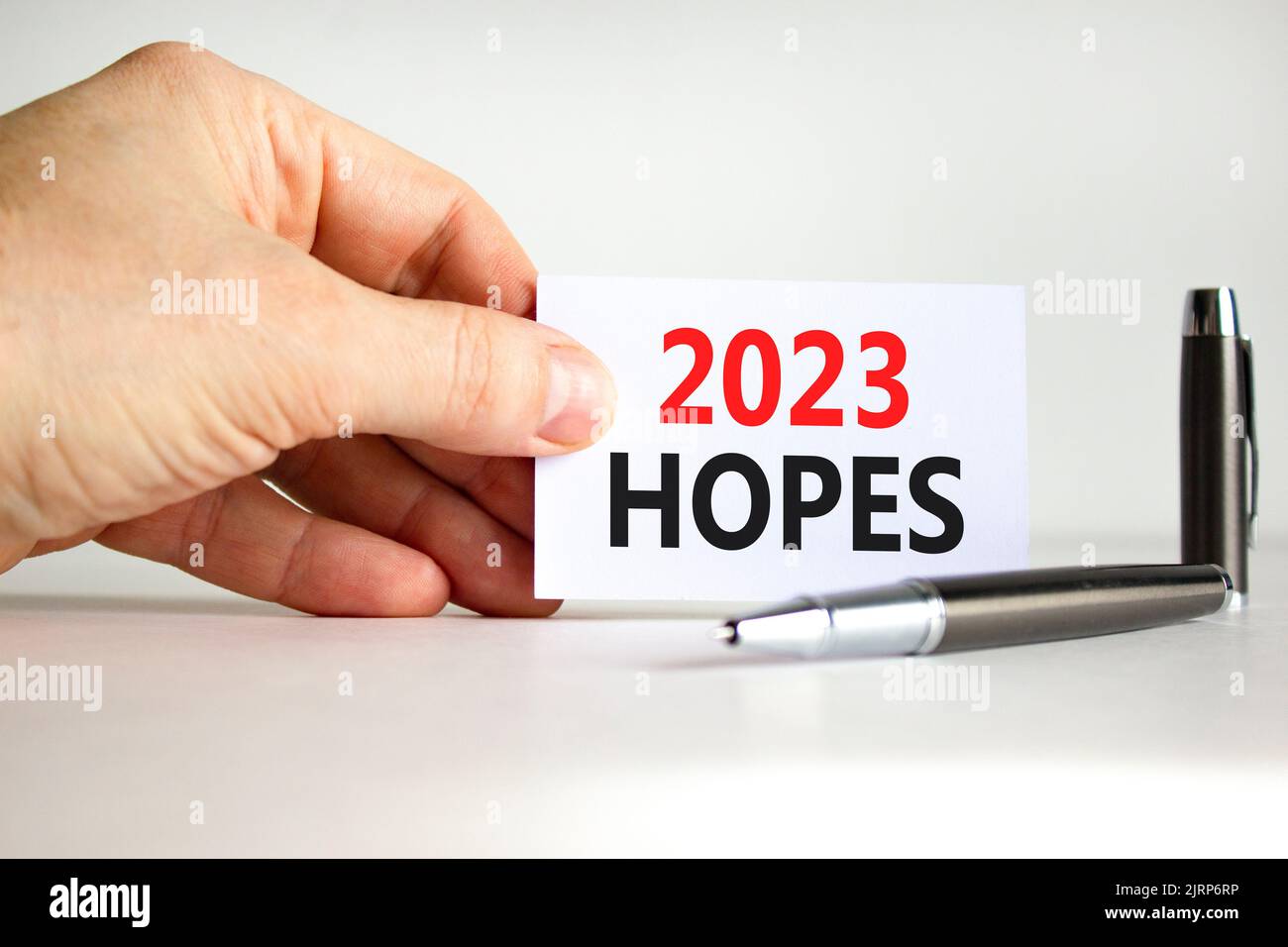 2023 Hopes symbol. White paper with words 2023 Hopes. Businessman hand ...
