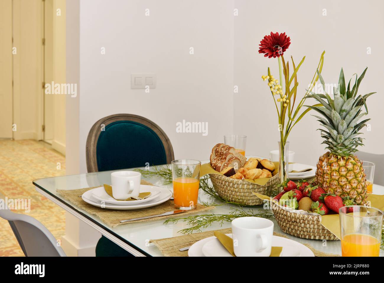 Dining table with glass top and wicker baskets with fresh fruits ...