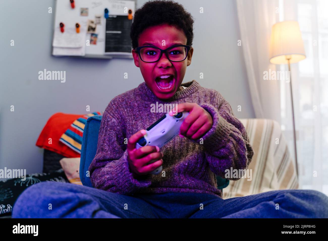 Black boy screaming while using joystick while playing online game at ...