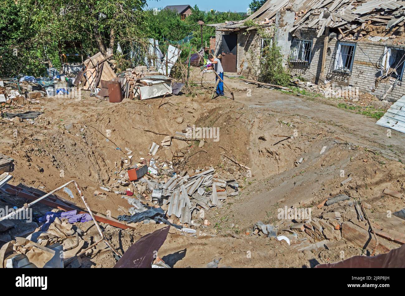 Dnipro, Ukraine - August 24, 2022:Owner of estate sorts out rubble and ...