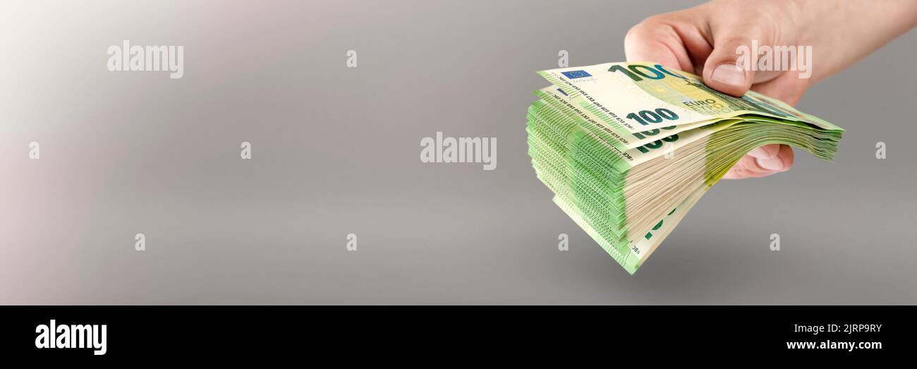 Large stack of euros in hand. Banknotes of 100 euros in a male hand on ...
