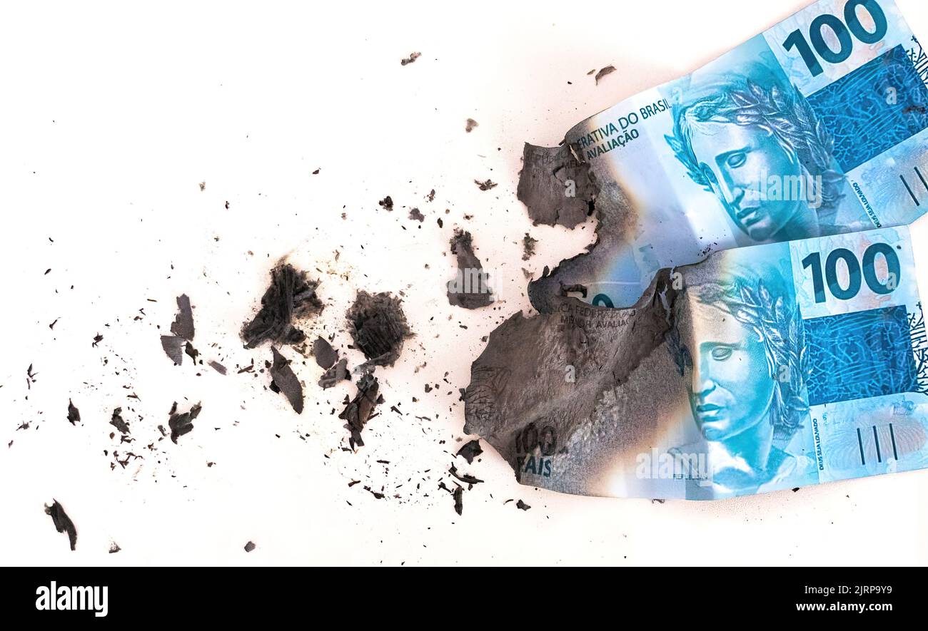 Brazilian money, one hundred reais bills, partially burned, with ash ...