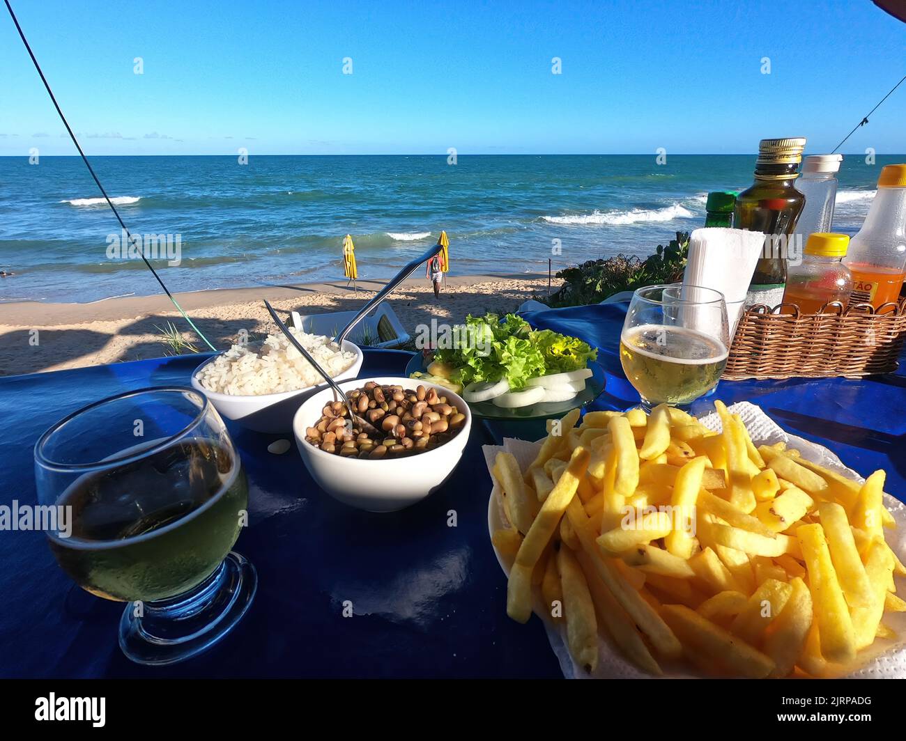 table set with typical Brazilian meal outdoors on the beach, northeast ...