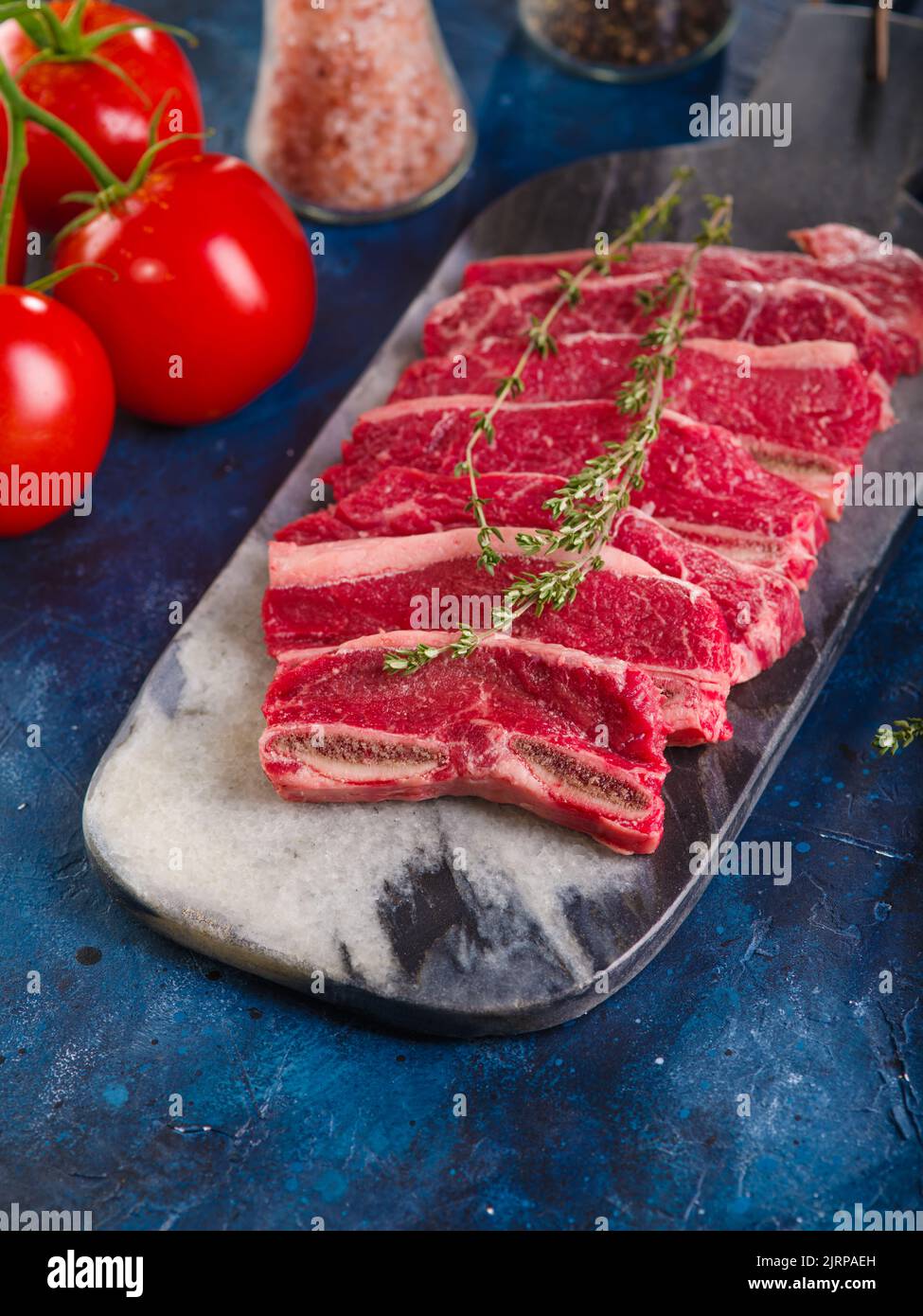On a dark blue background, raw meat steaks from organic meat from the ...