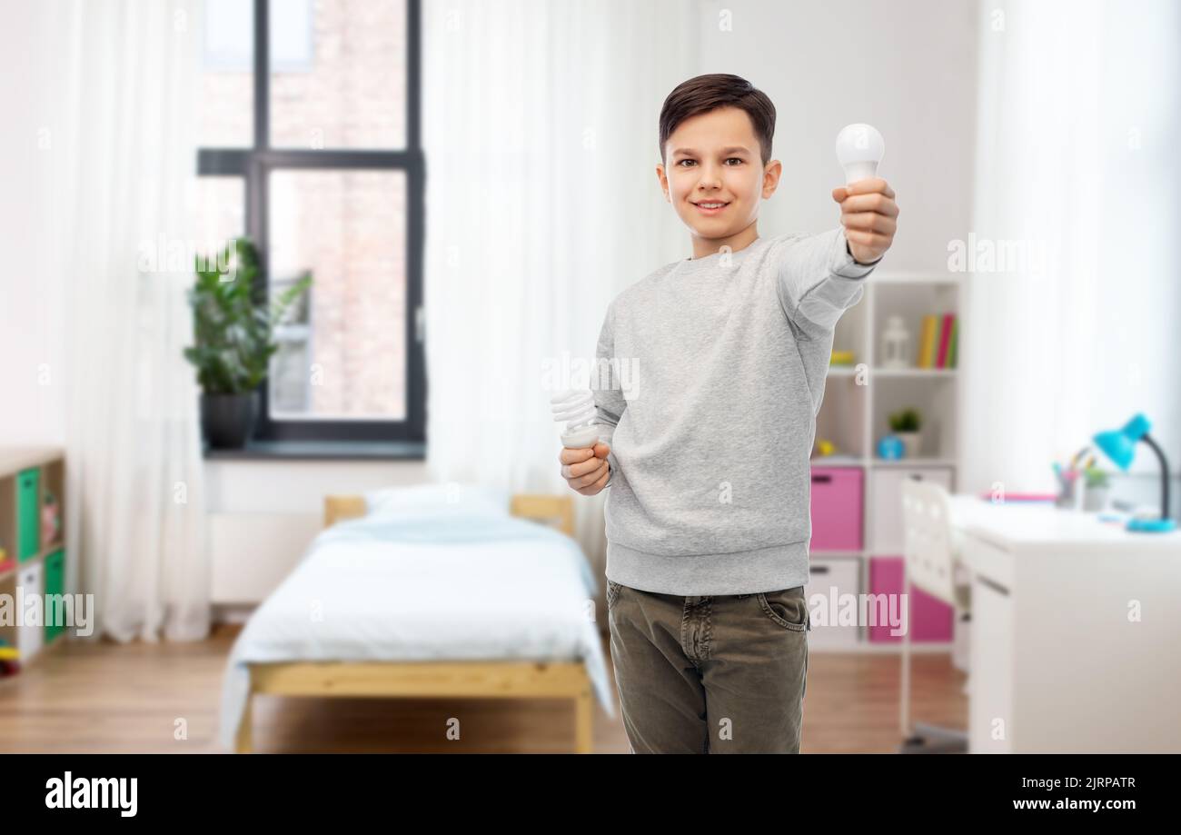 happy boy comparing different light bulbs at home Stock Photo - Alamy