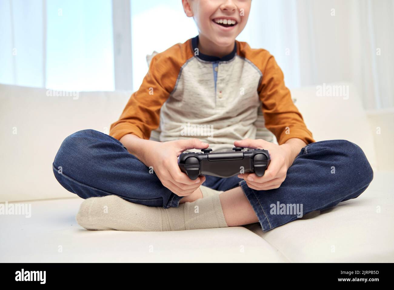 happy boy with gamepad playing video game at home Stock Photo - Alamy