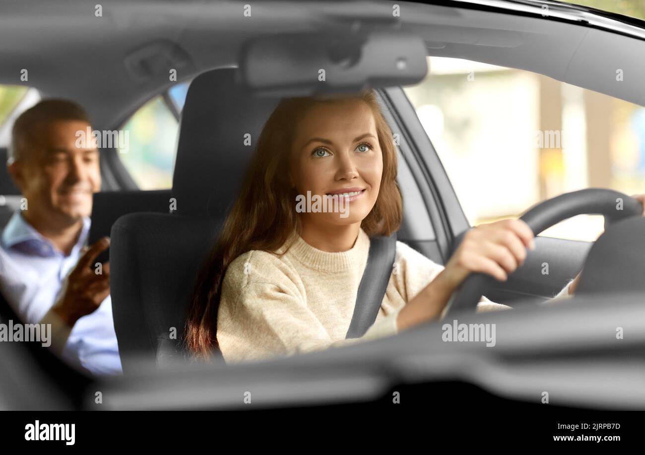 female driver driving car with male passenger Stock Photo - Alamy