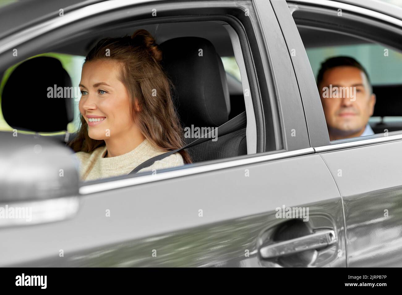 female driver driving car with male passenger Stock Photo - Alamy