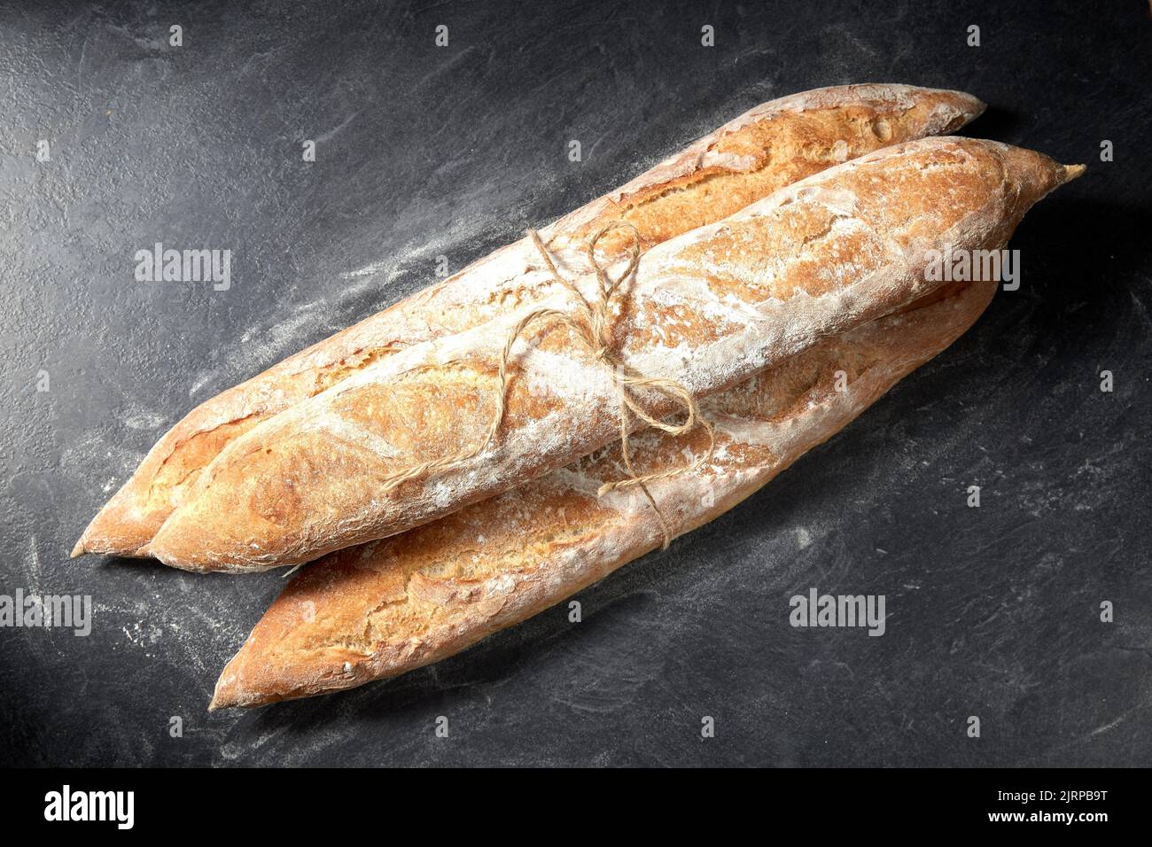 pile of baguette bread loaves tied with rope Stock Photo - Alamy