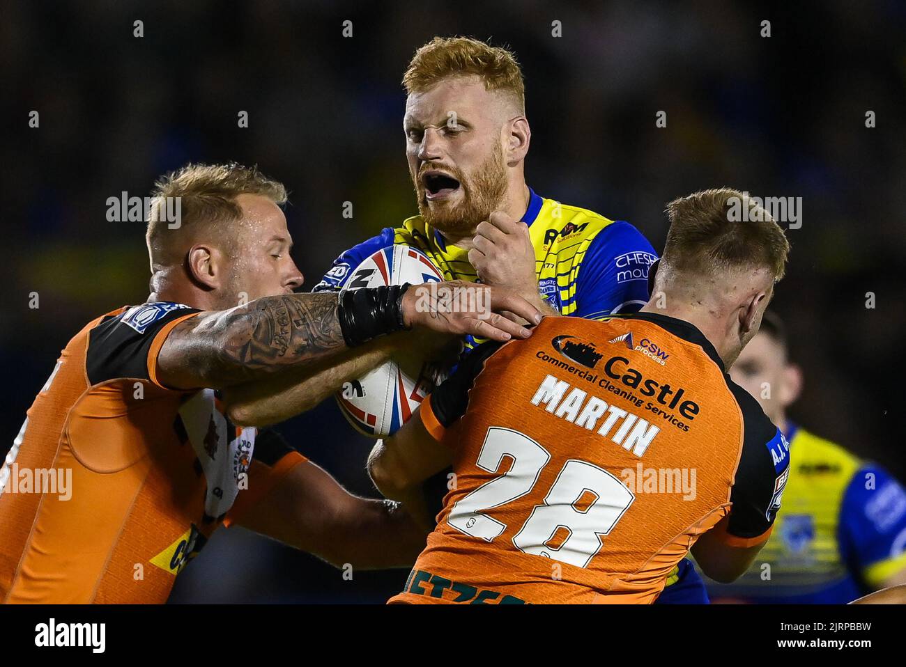 Joe Bullock #15 of Warrington Wolves is tackled by Brad Martin #28 and ...