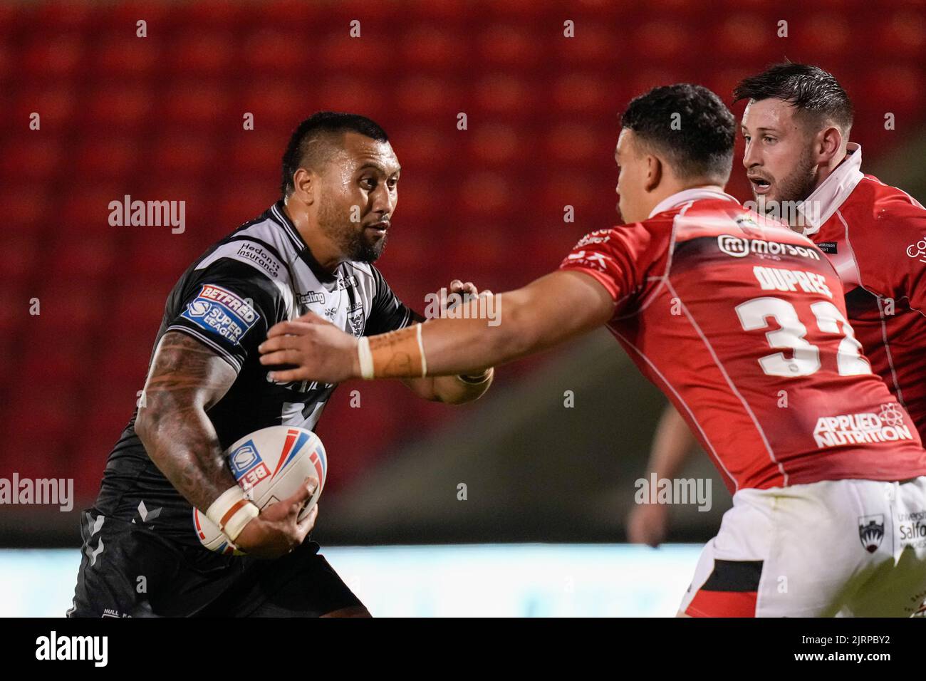 Ligi Sao #8 of Hull FC runs at Tyler Dupree #32 of Salford Red Devils ...