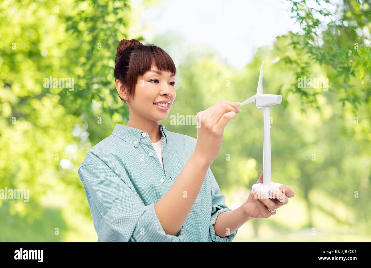 smiling young asian woman with toy wind turbine Stock Photo - Alamy