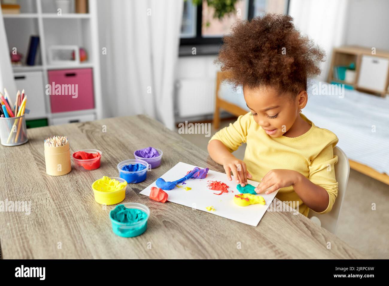 little girl with modeling clay playing at home Stock Photo - Alamy