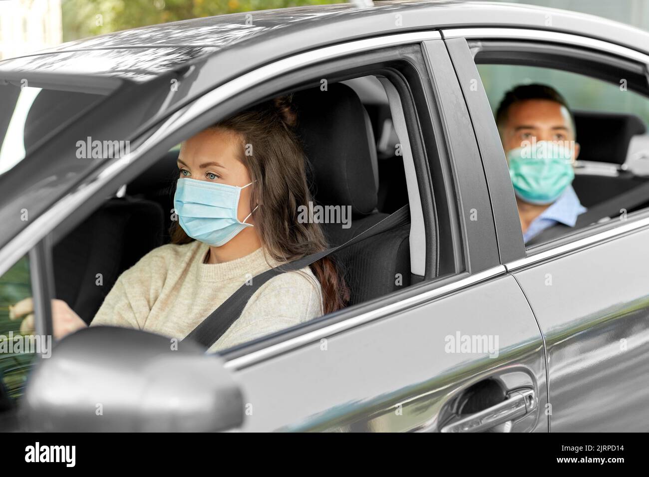 female driver in mask driving car with passenger Stock Photo - Alamy