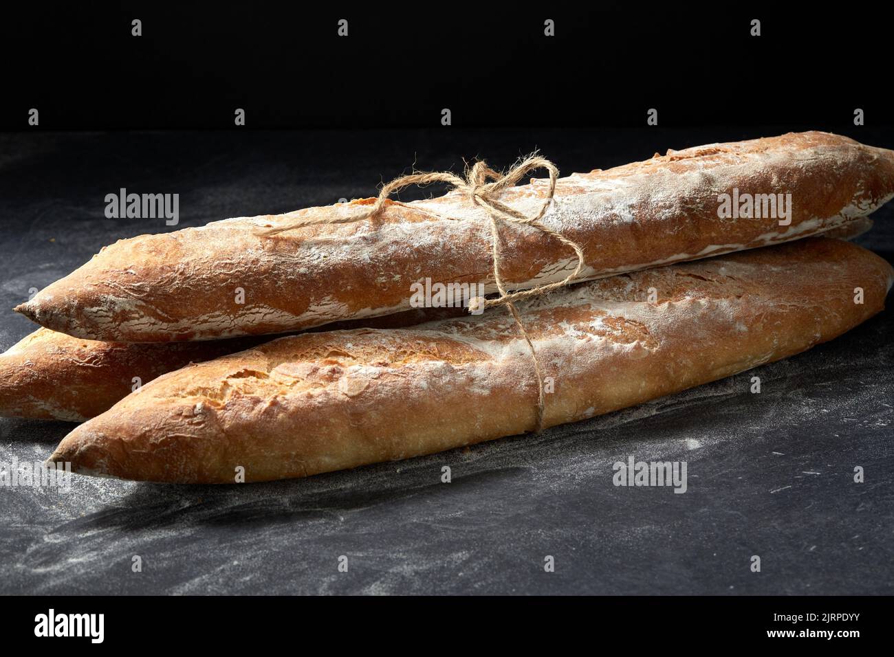 pile of baguette bread loaves tied with rope Stock Photo - Alamy
