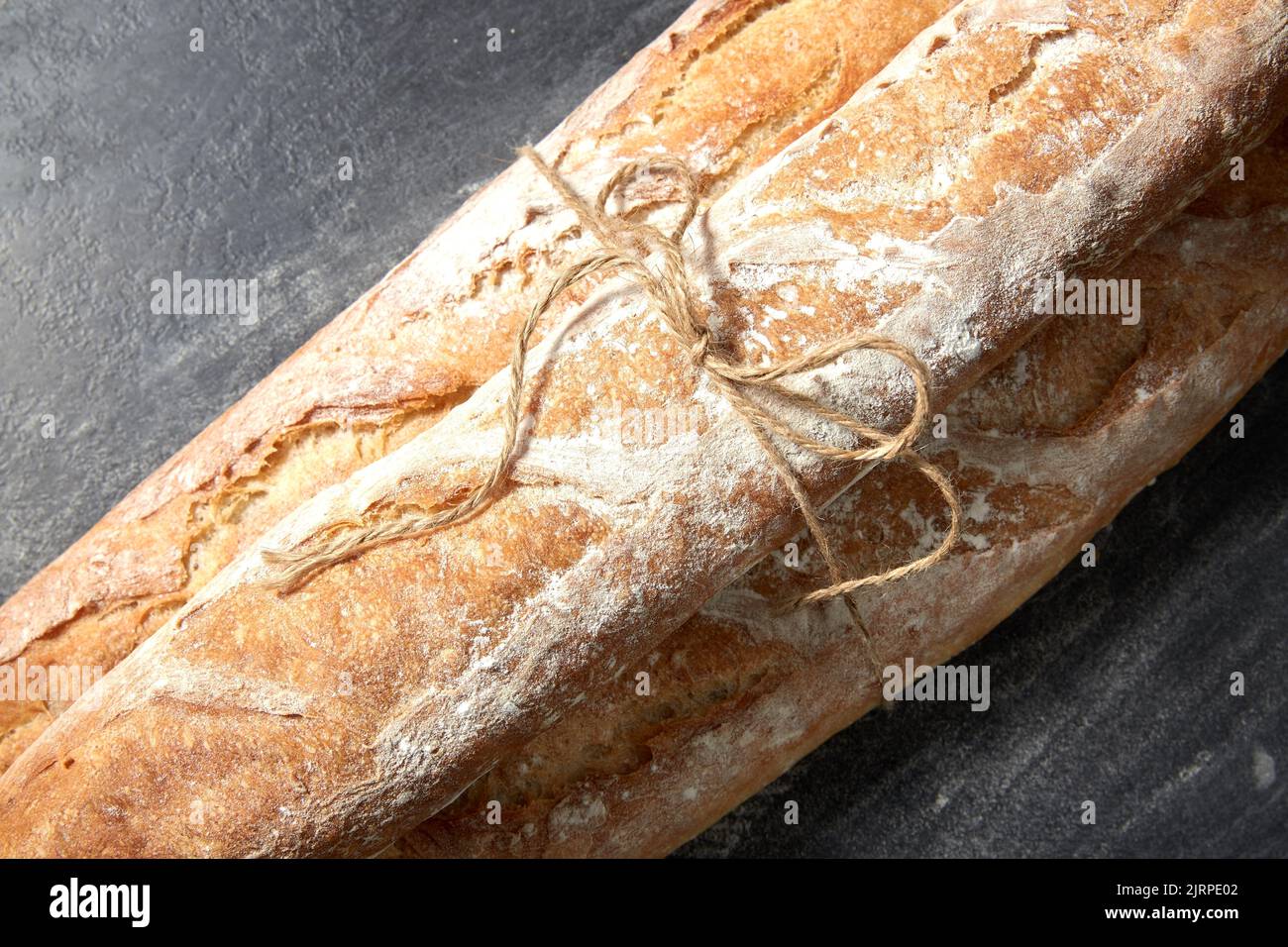 pile of baguette bread loaves tied with rope Stock Photo - Alamy