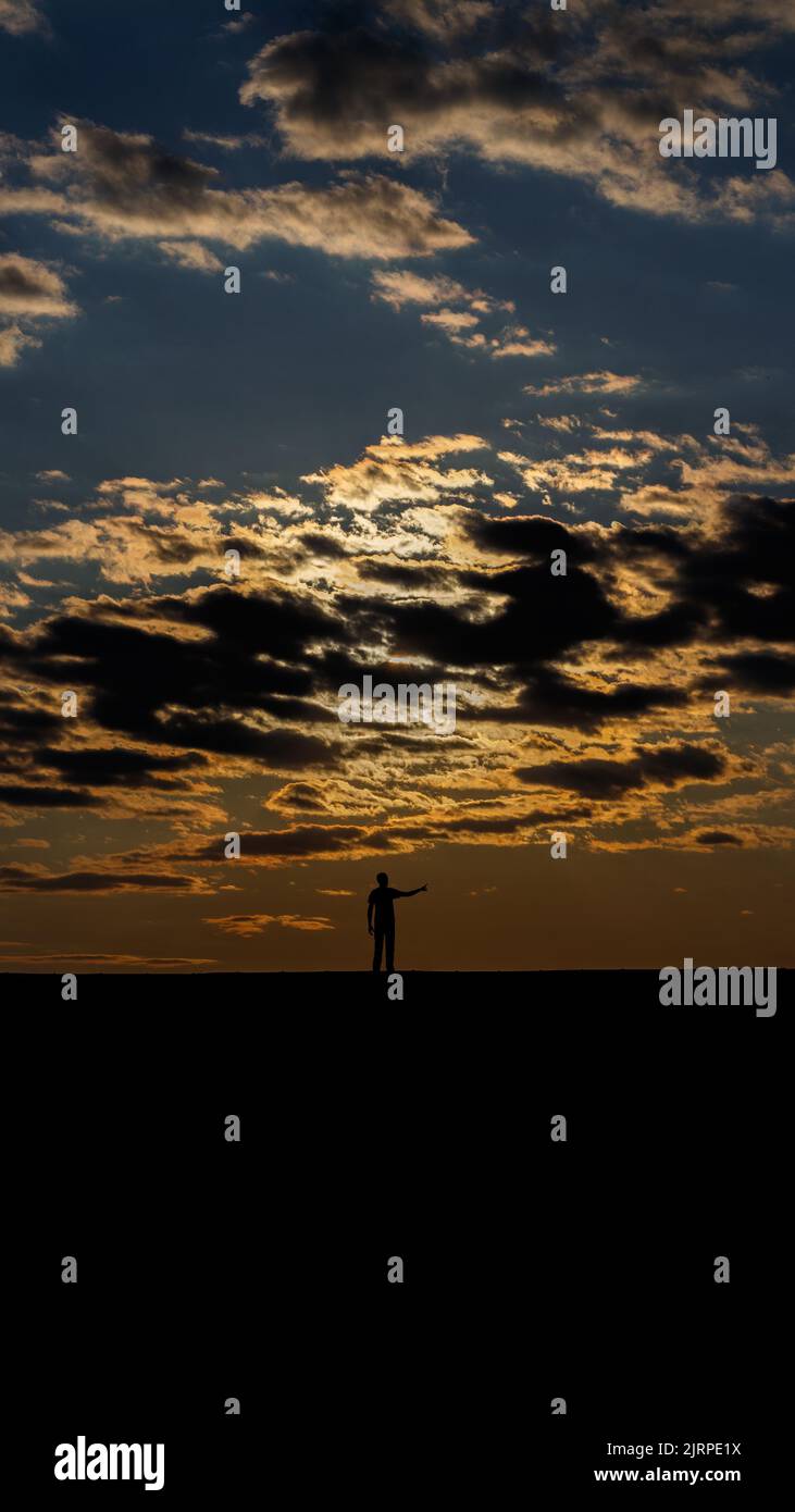 The silhouette of a man holding a pose during a beautiful sunset Stock ...