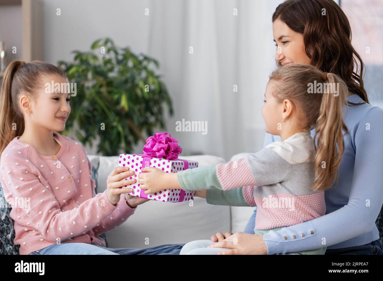 girl giving present to younger sister at home Stock Photo - Alamy