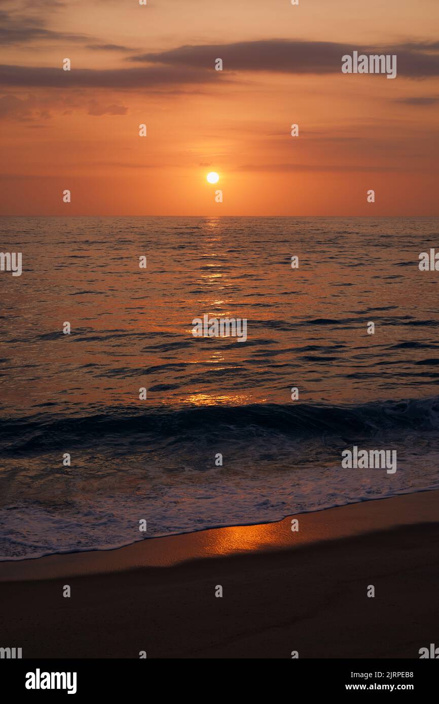 A vertical shot beautiful sunset over the ocean with yellow horizon and ...